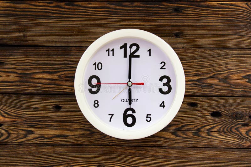 A White Clock Showing the Time on a Wooden Wall Stock Image - Image of ...