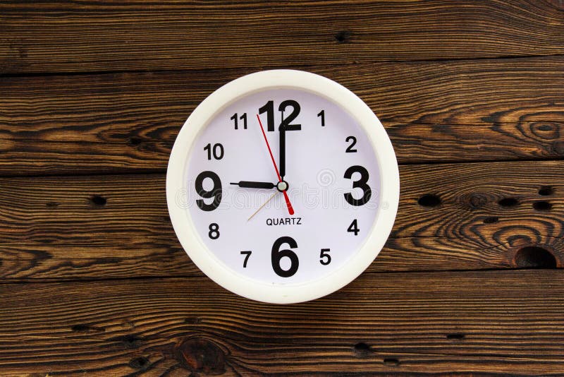 A White Clock Showing the Time on a Wooden Wall Stock Image - Image of ...