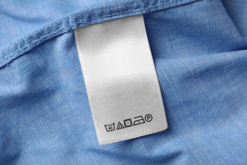 White Clothing Label on Light Blue Garment, Closeup Stock Photo - Image ...