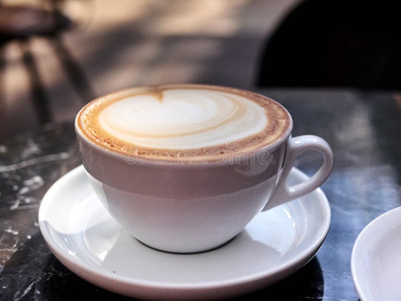 A White Coffee Cup with a White Saucer Sits on a Table Stock Image ...