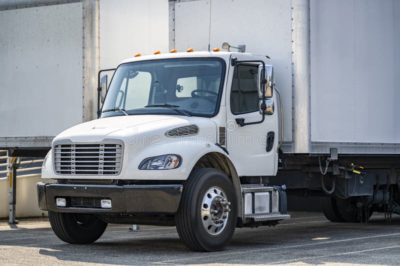 Two Compact Middle Day Cab Rig Semi Trucks with Box Trailers Standing ...