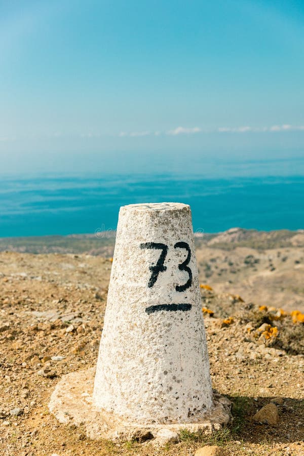 Concrete Milestone with Notes on the Sandy Ground with the Background ...