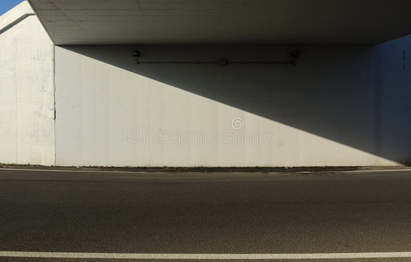White Concrete Wall Under an Underpass Divided in Two Obliquely by a ...