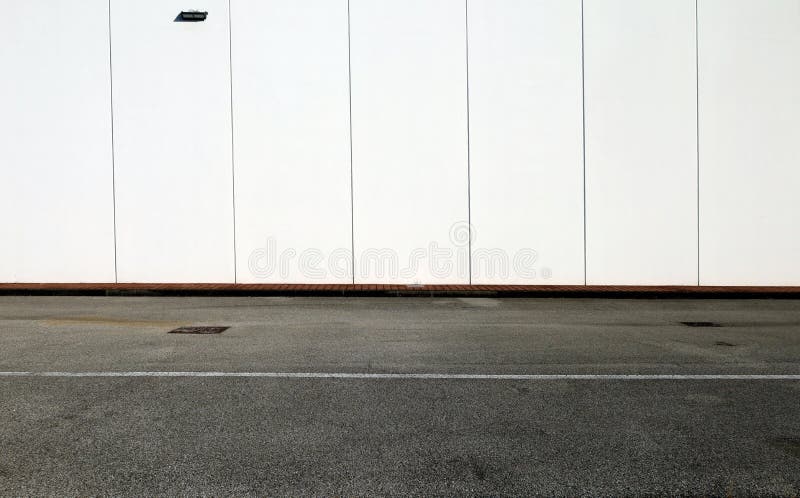 White Concrete Wall with Vertical Blocks, a Brown Sidewalk and an ...