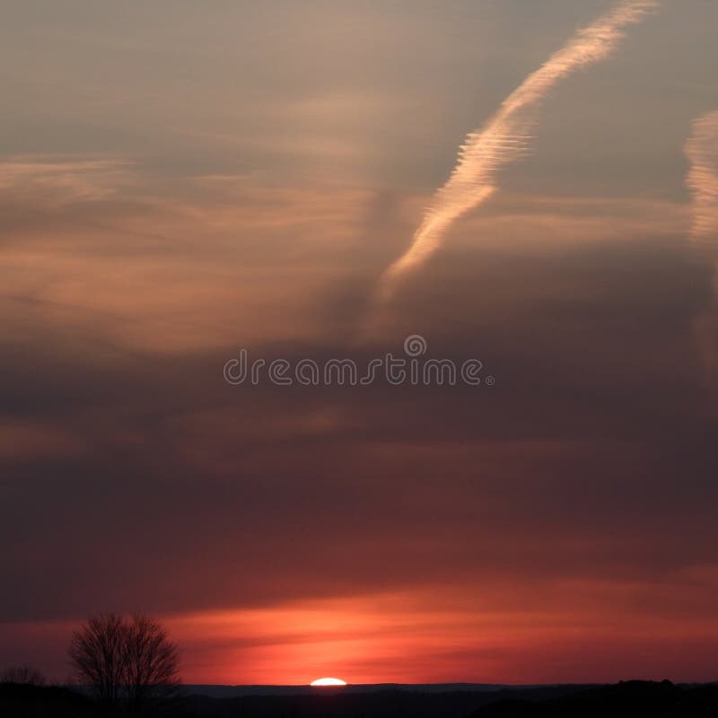 White Jet Contrail Expands with Shadow Over Orange FLX Sunset Stock ...