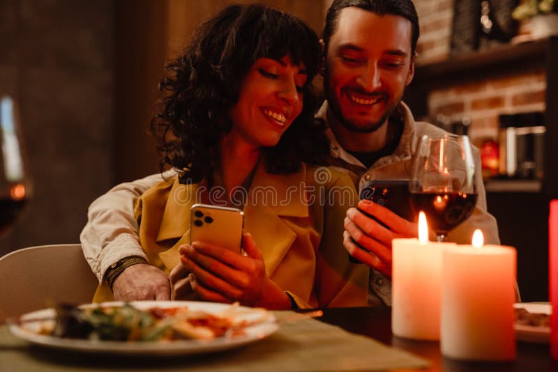 White Couple Using Mobile Phones during Romantic Date at Home Stock ...