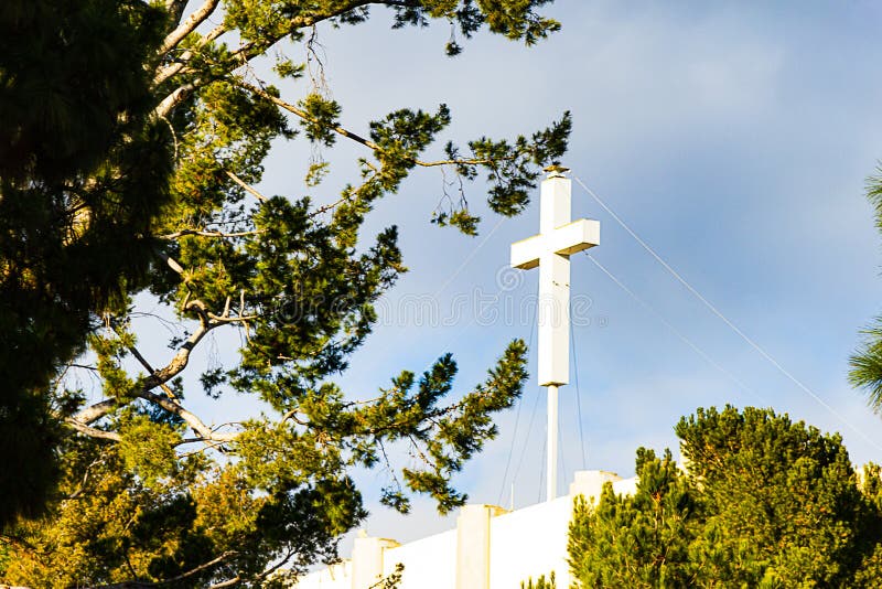 White Cross on Blue Sky, with Trees and Building Edge Stock Image ...