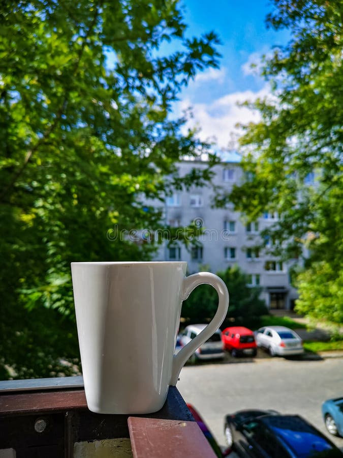White Cup of Coffee Standing on Edge of Balcony Railing Stock Photo ...
