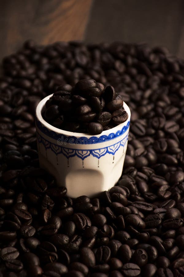White Cup Surrounded by Coffee Beans on a Bed of Beans Stock Photo ...