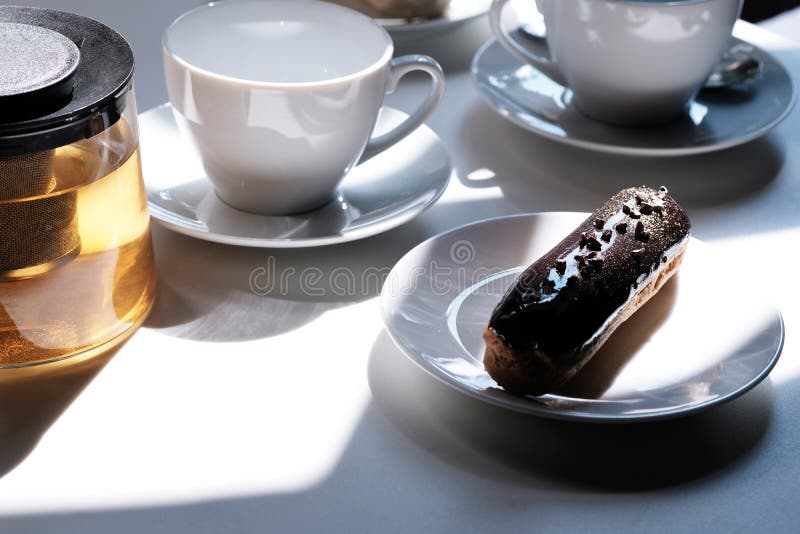 Cup of Tea and Eclair on the Table Stock Photo - Image of summer, glass ...