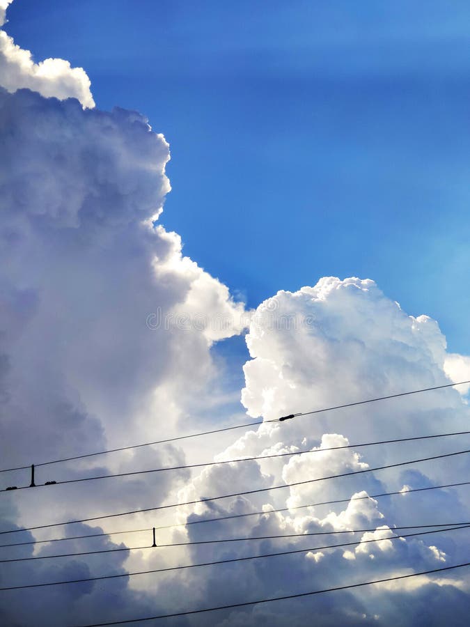 White Curly Clouds on the Blue Sky and Electrical Wires Stock Image ...