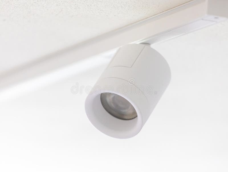 White Cylindrical Spotlight Hanging from Ceiling Track Lighting System ...