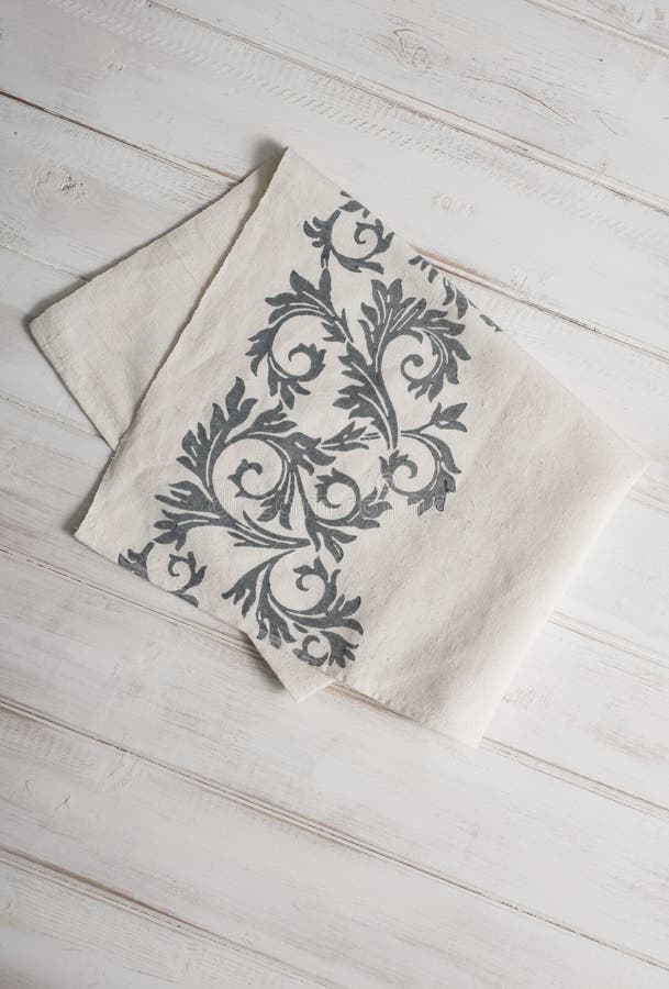 White Dinner Napkin with Black Floral Pattern on Wooden Surface Stock ...