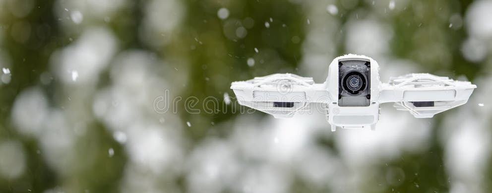 A White Drone with a Camera on it Flying through the Snow Stock Photo ...