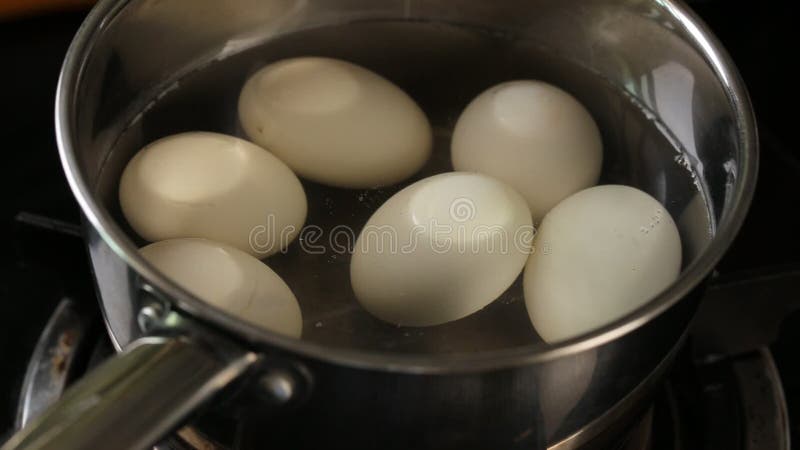 Two Eggs Boiling in Hot Water in a Cooking Pot on Gas Stove Stock ...