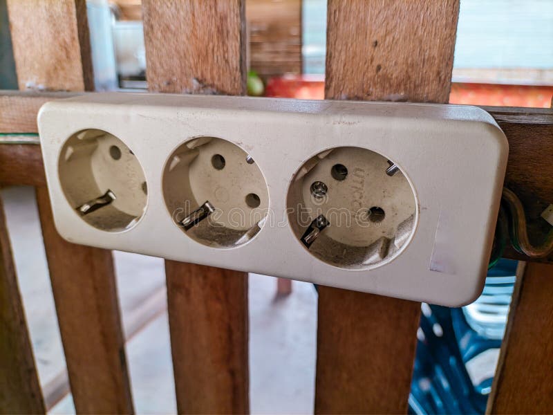 White Electric Socket on Wooden Wall. Power Plug with Wire in Socket ...