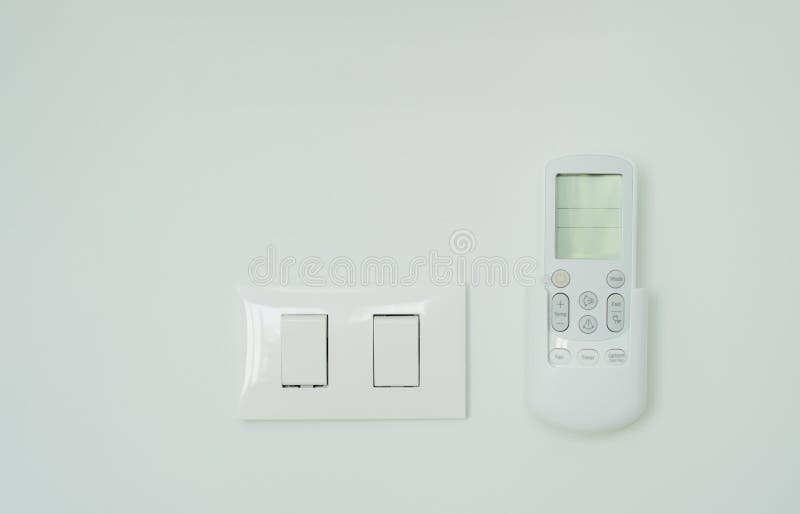 White Electric Switch and Air Conditioner Remote Control on the White ...