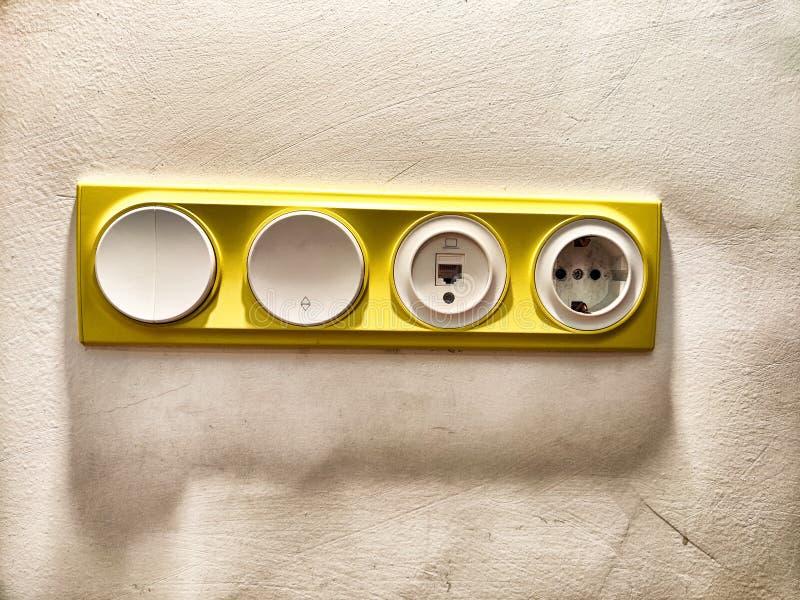 A White Electrical Outlet and Light Switch Mounted on a Textured Wall ...