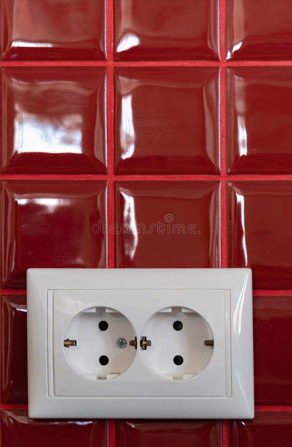 White Electrical Outlet on a Red Ceramic Tile Wall with Conductive ...