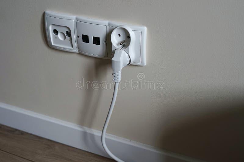 A White Electrical Outlet on the Wall in the Room. an Electric Plug ...