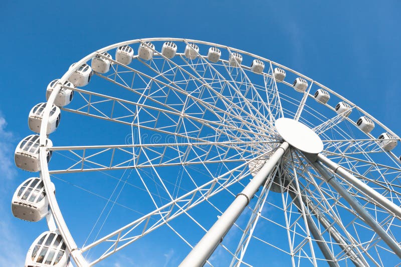 White Ferris Wheel with Glass Light Blue Cabins Against Blue Sky, Dubai ...