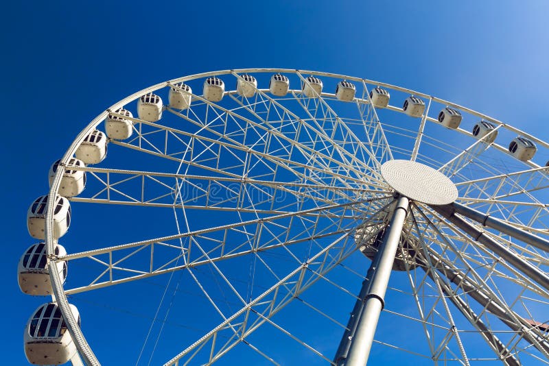 White Ferris Wheel with Glass Light Blue Cabins Against Blue Sky, Dubai ...
