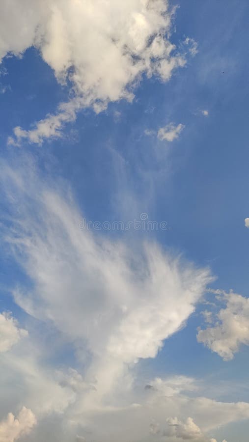 White Fluffy Clouds Moving Across a Clear Blue Sky Stock Photo - Image ...