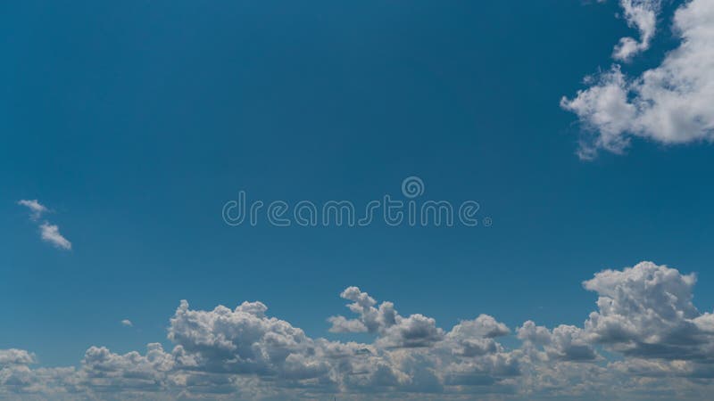 White Fluffy Clouds Slowly Float through the Blue Daytime Sky Timelapse ...