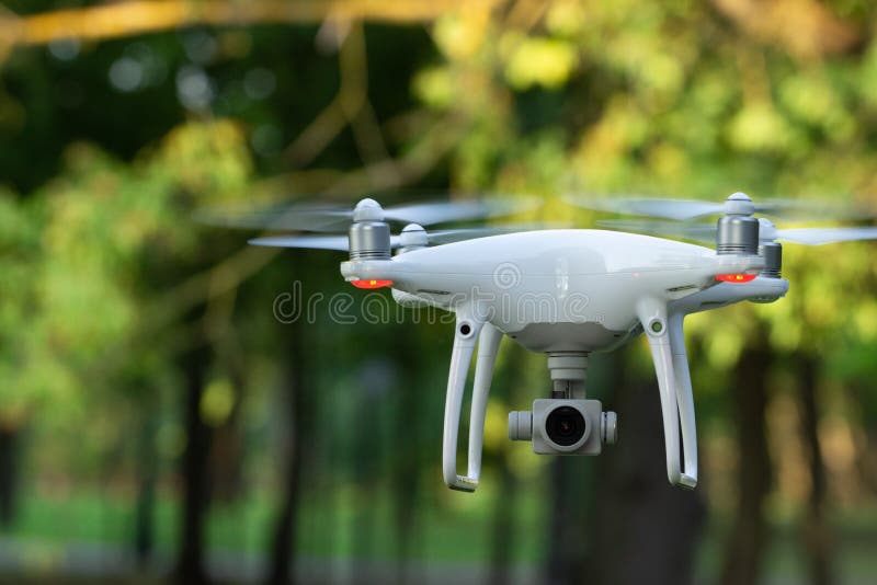 White Flying Drone with Camera on Green Trees Background Stock Photo ...