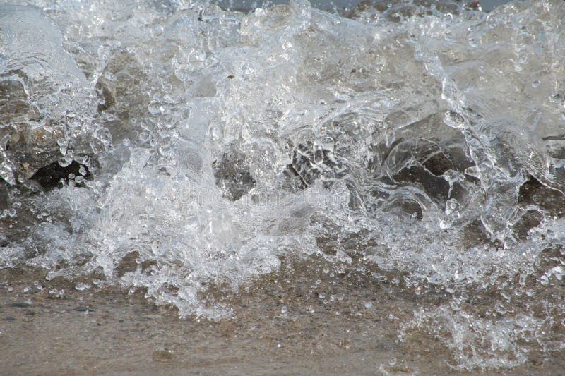 White Foam and Sea Water Drop Splashes Slow Motion with Sand and Blue ...