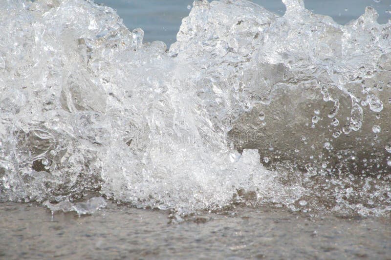 White Foam and Sea Water Drop Splashes Slow Motion with Sand and Blue ...