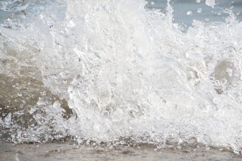 White Foam and Sea Water Drop Splashes Slow Motion with Sand and Blue ...