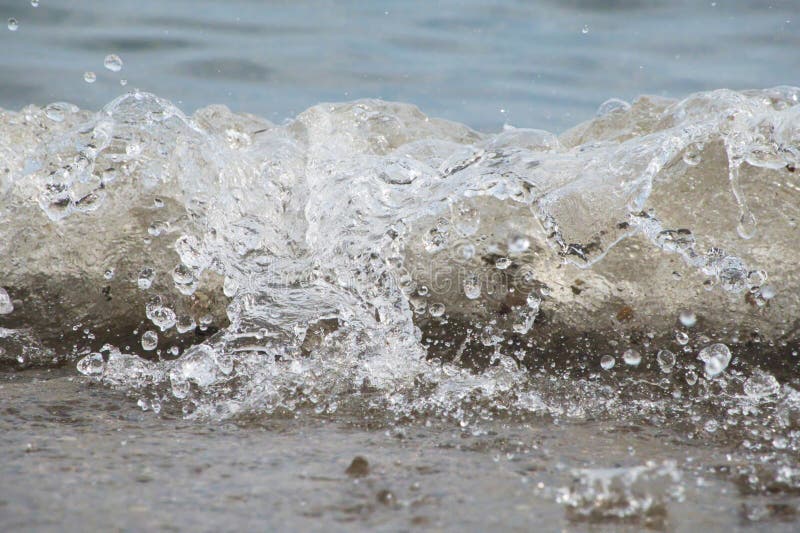 White Foam and Sea Water Drop Splashes Slow Motion with Sand and Blue ...