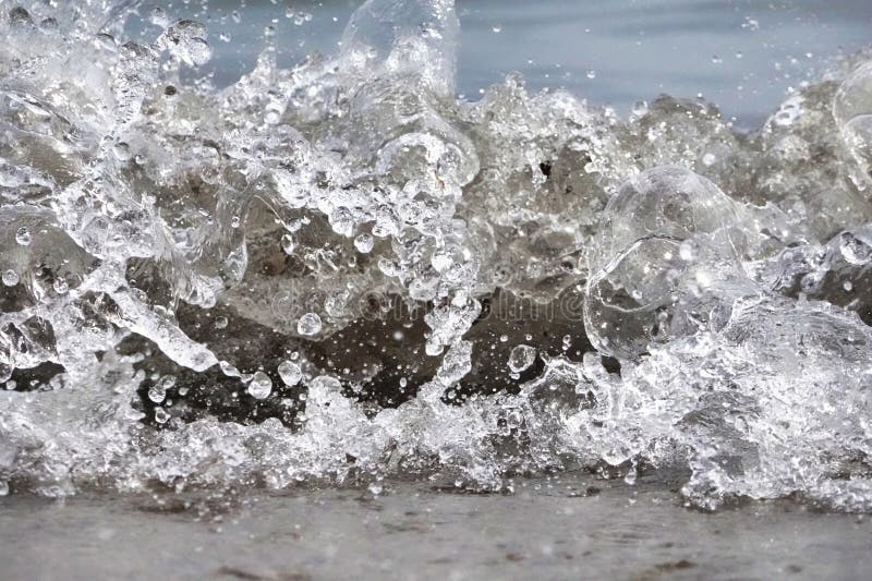 White Foam and Sea Water Drop Splashes Slow Motion with Sand and Blue ...