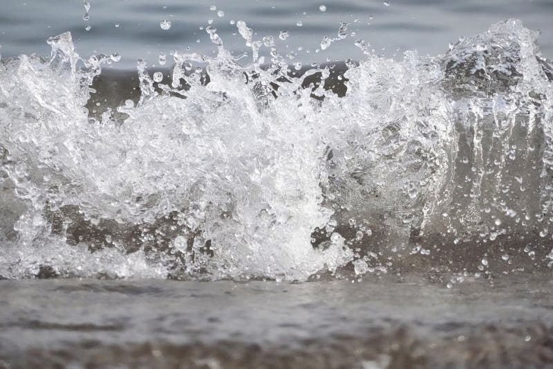 White Foam and Sea Water Drop Splashes Slow Motion with Sand and Blue ...
