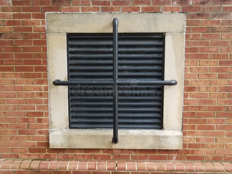 White Frame with Black Bars on Red Brick Wall and Ventilation Vent ...