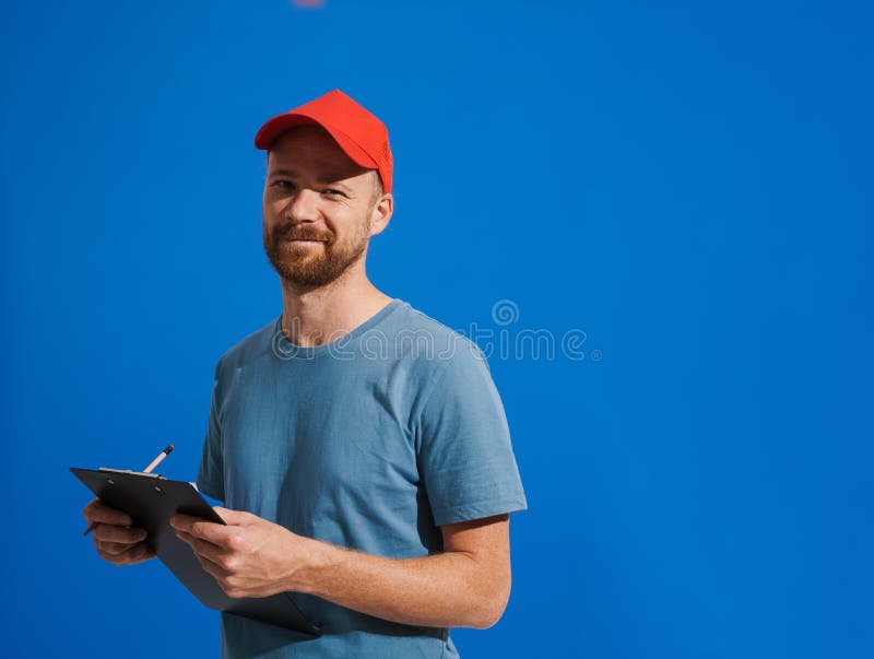 White Ginger Man Wearing Cap Smiling and Writing on Clipboard Stock ...