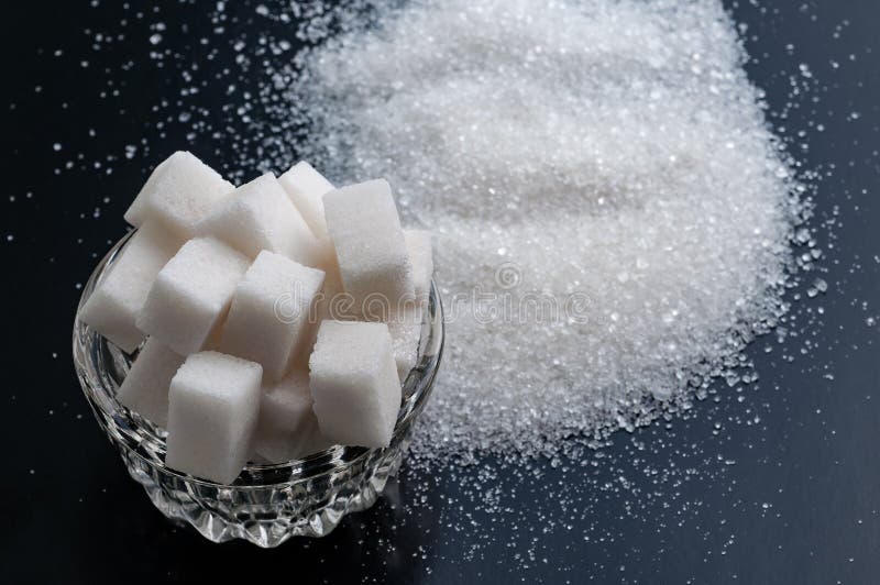 White Granulated Sugar and Refined Sugar on Black Table Surface. Stock ...