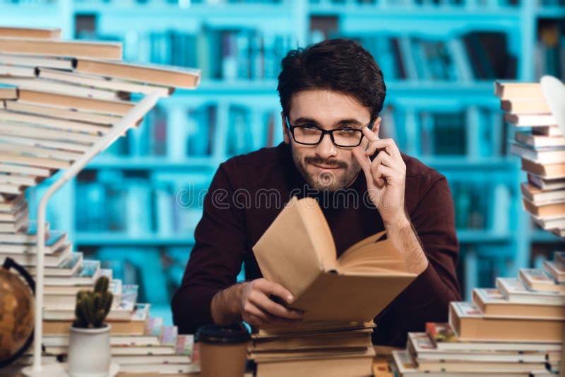 White Guy Surrounded by Books in Library. Student is Reading Book ...