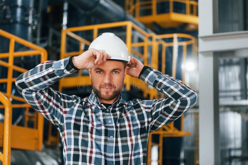 In White Hard Hat. Construction Worker in Uniform is in the Factory ...