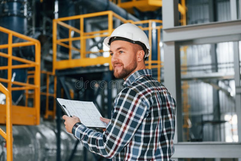 In White Hard Hat. Construction Worker in Uniform is in the Factory ...