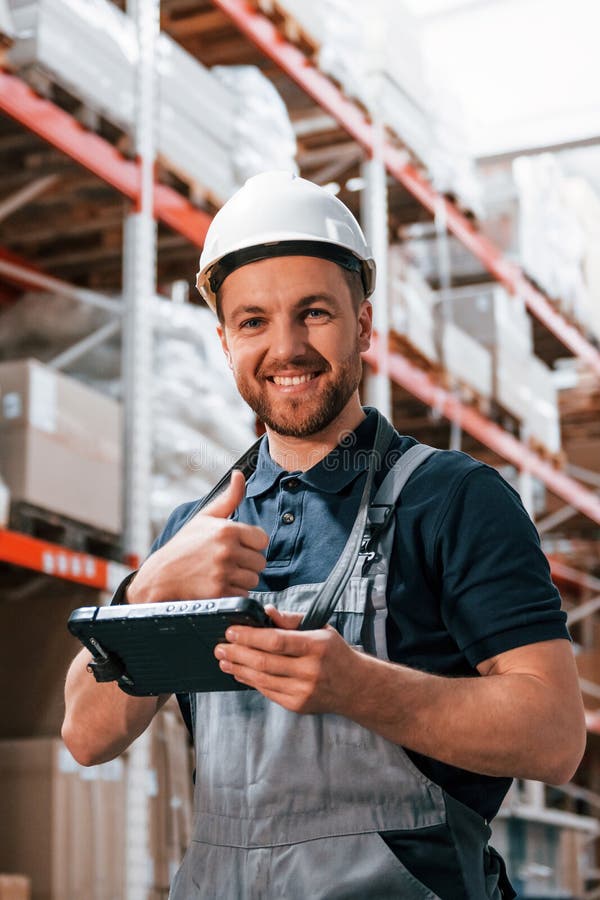 In White Hard Hat and with Tablet. Employee in Uniform is Working in ...