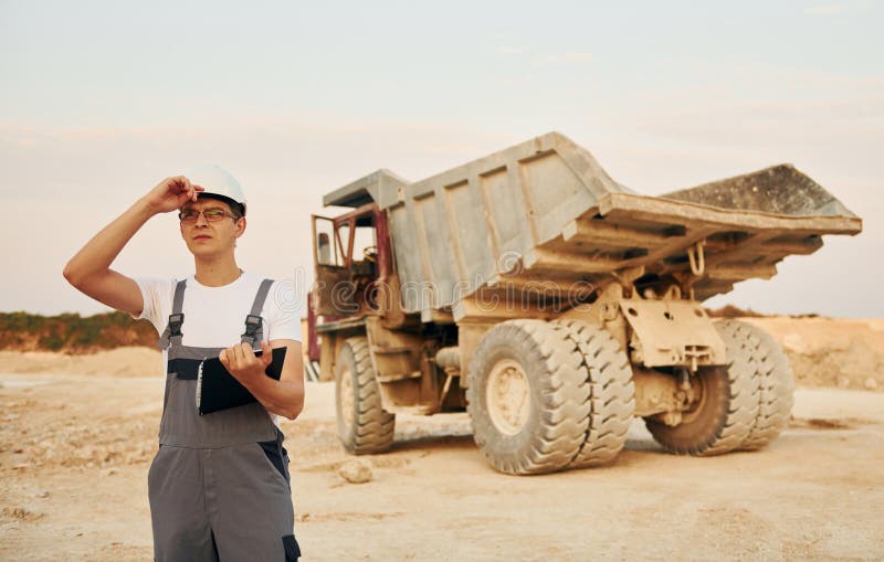 In White Hard Hat. Worker in Professional Uniform is on the Borrow Pit ...