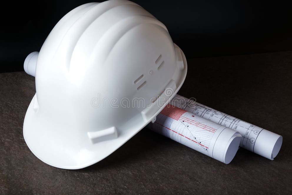 White Hardhat and Rolled Engineering Drawings at Engineer Workplace ...
