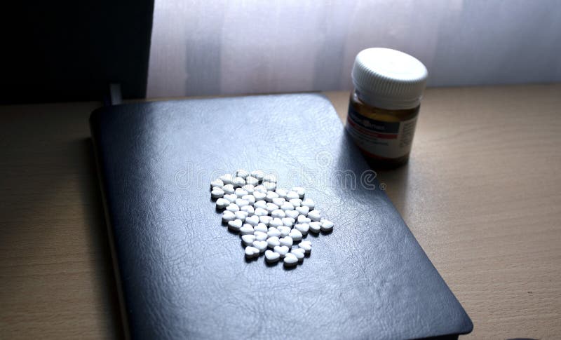 White Heart Pills Lie on a Blue Notebook on the Table Stock Image ...
