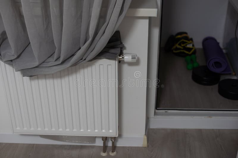 White Heater with Radiator and a Modern Thermostat on the Wall in an ...
