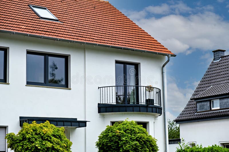 White House with Red Roof and Decorative Balcony on the Second Floor in ...