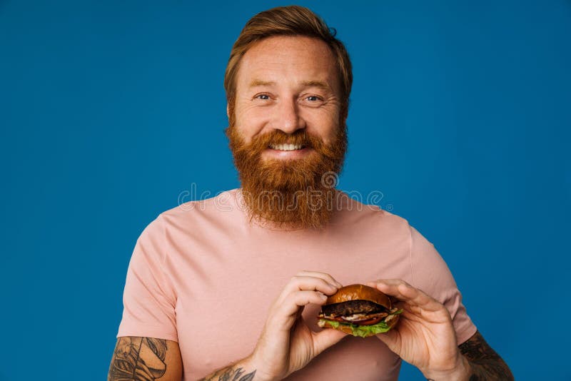 Happy Hungry Bearded Man Eating Burger Isolated on Blue Background ...