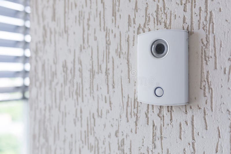 A White Incoming Electronic Doorbell with a Camera on the Wall of the ...