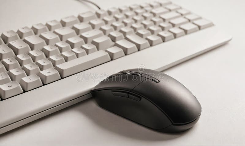 A White Keyboard and a Black Mouse Sit on a Desk, Ready for Use Stock ...